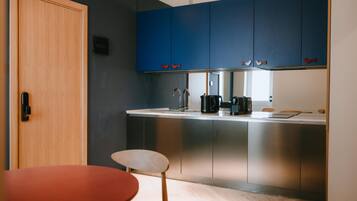 Uma cozinha moderna com armários azuis, eletrodomésticos de aço inoxidável e uma porta de madeira.