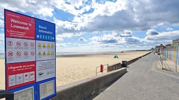 Placa de informações da praia com orientações de segurança e horários dos salva-vidas.