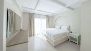 Quarto moderno com uma cama grande, mesa de cabeceira, espelho e janela com cortinas.
