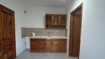 Uma cozinha com armários de madeira, painel de azulejos e uma luminária no teto.