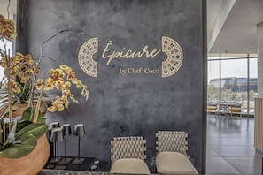 Um interior moderno com uma parede escura, um logotipo e duas cadeiras.