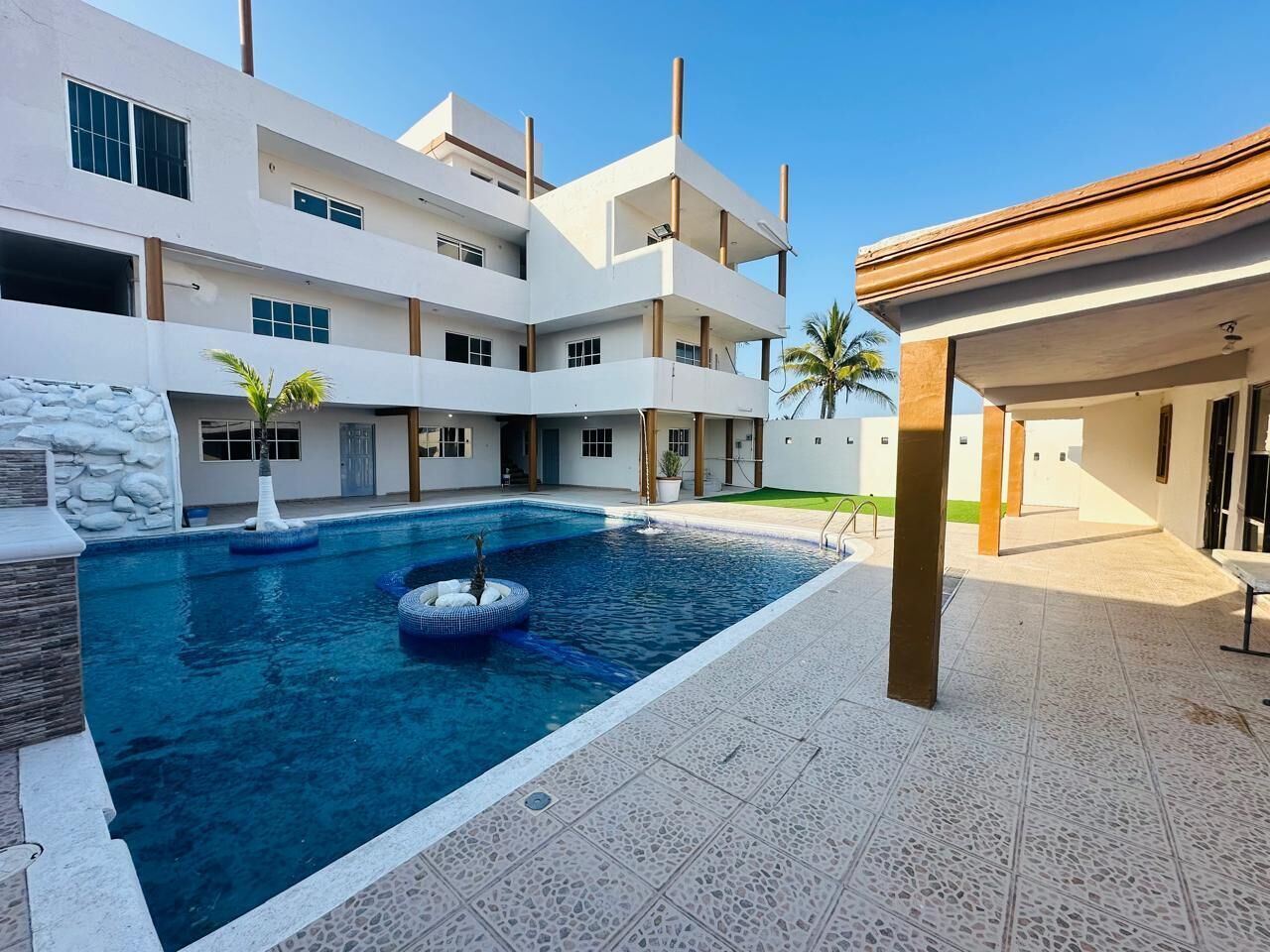 Um edifício moderno com piscina, área de estar ao ar livre e um alpendre coberto.