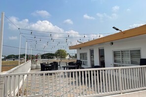 Um edifício com varanda, área de estar externa e luzes de Natal.