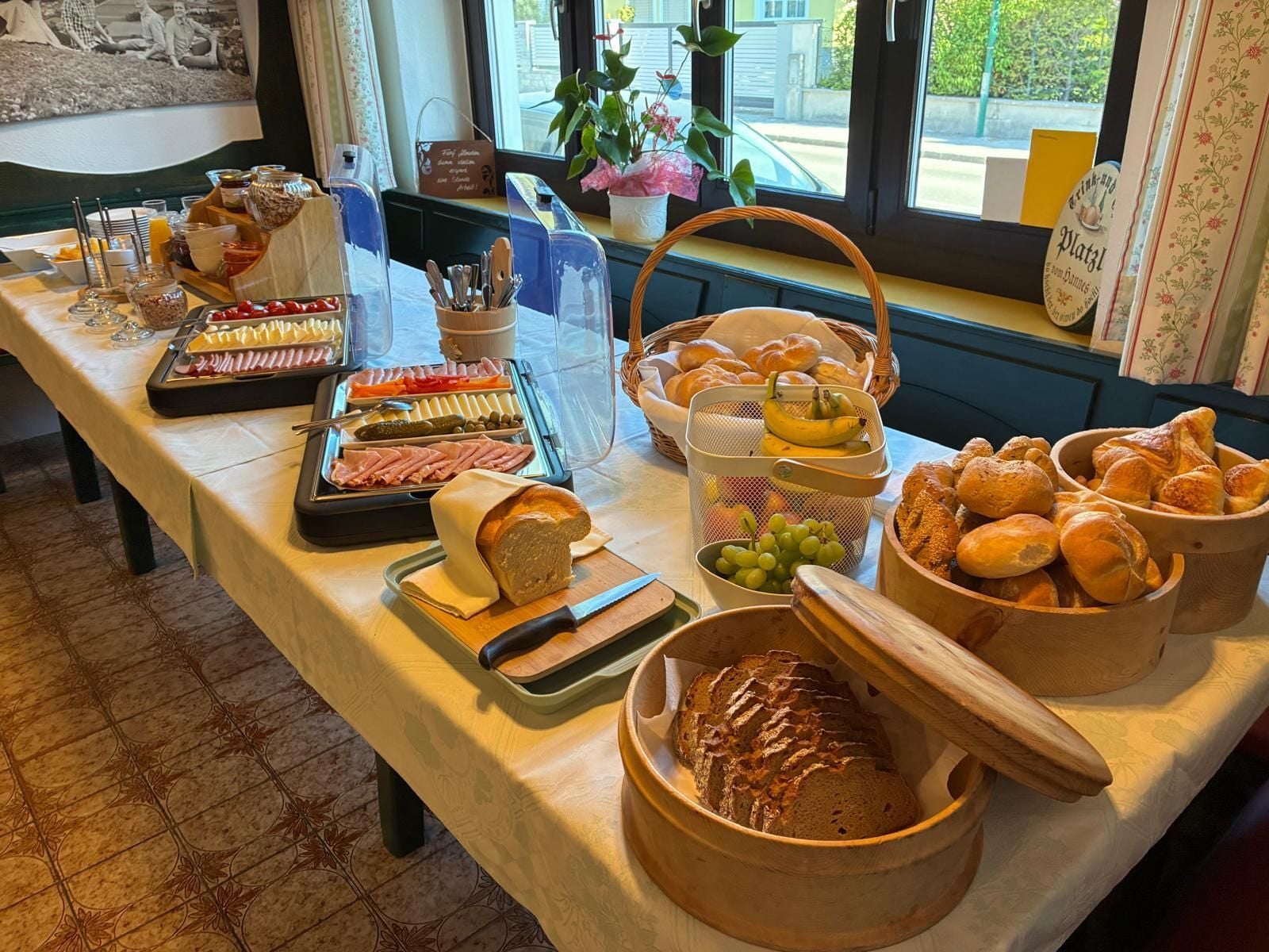 Uma mesa de buffet com diversos alimentos, incluindo pão, frutas e carnes.