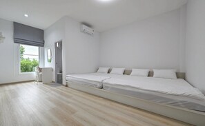 Quarto moderno com uma cama grande, uma escrivaninha e uma janela.