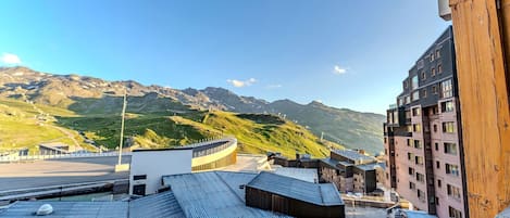Vista de uma paisagem montanhosa com edifícios ao primeiro plano.