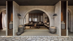 Uma sala moderna com um conjunto de sofás, mesa de centro e vasos decorativos.