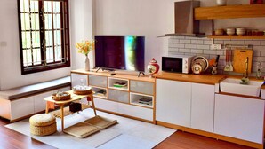 Cozinha moderna com televisão de tela plana, micro-ondas e armários de madeira.
