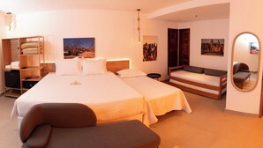 Quarto com uma cama grande, um sofá, uma escrivaninha e um guarda-roupa.