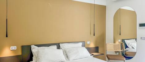 Quarto de hotel com cama, mesas de cabeceira, um espelho e ar condicionado.