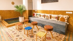 Quarto com sofá, piscina pequena e tapete estampado.