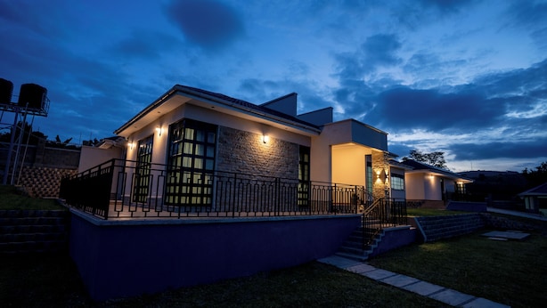 Uma casa moderna com fachada de pedra, janelas amplas e exterior bem iluminado.