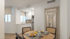 Uma sala de jantar moderna com uma mesa redonda, cadeiras e itens de café da manhã.