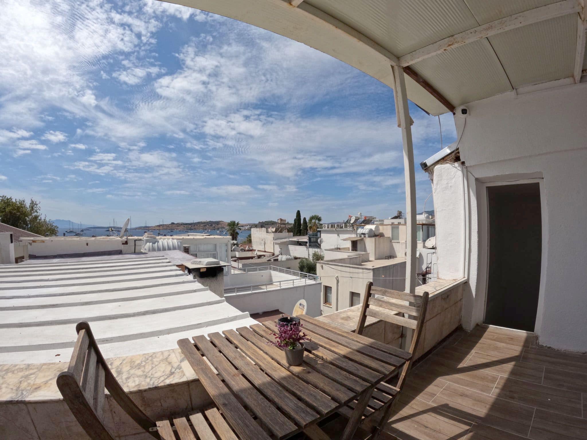 Terraço no telhado com vista para o mar e edifícios.