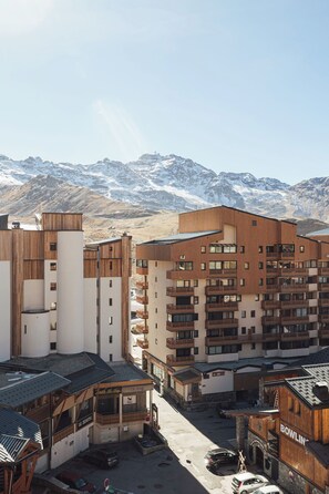 Um complexo de edifícios modernos com várias varandas e uma loja de artigos para esqui.