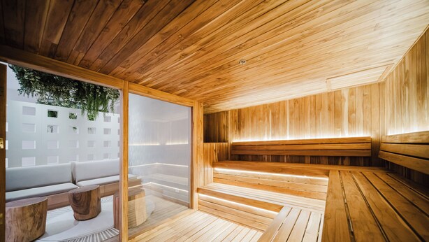 Uma sauna de madeira com bancos e um espaço para sentar.