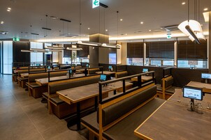 Um restaurante moderno com assentos tipo cabine e iluminação pendente.