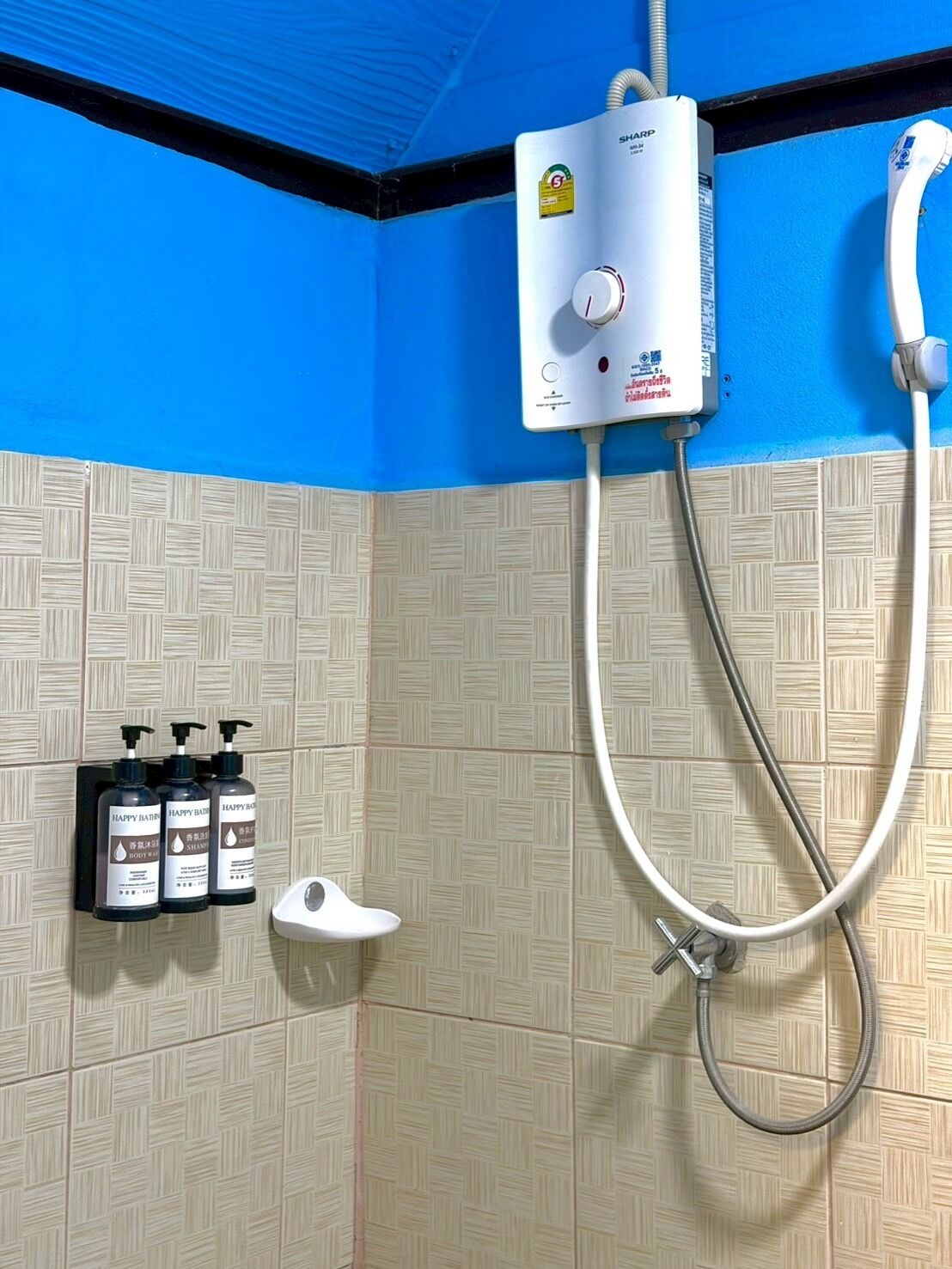 Um chuveiro com painel de controle, um chuveiro manual e duas garrafas de shampoo.