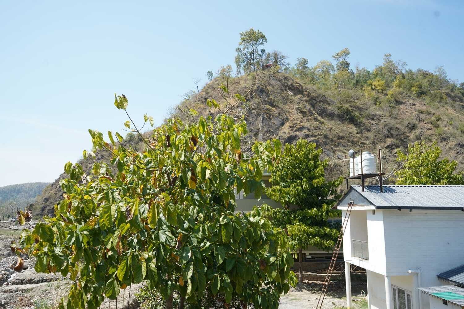 Um edifício com fachada branca, uma escada e um reservatório de água no telhado.