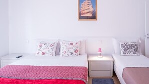 Quarto de hotel com uma cama, duas mesas de cabeceira, um abajur e um quadro na parede.