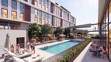 Um hotel moderno com piscina no terraço, área de estar ao ar livre e um jardim paisagístico.