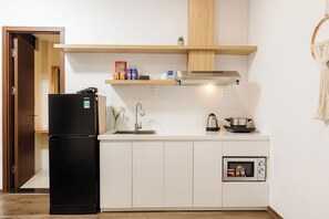 Uma cozinha compacta com geladeira preta, micro-ondas e fogão.