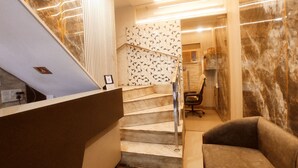 Uma escadaria com parede estampada, um banco acolchoado e um certificado emoldurado na parede.