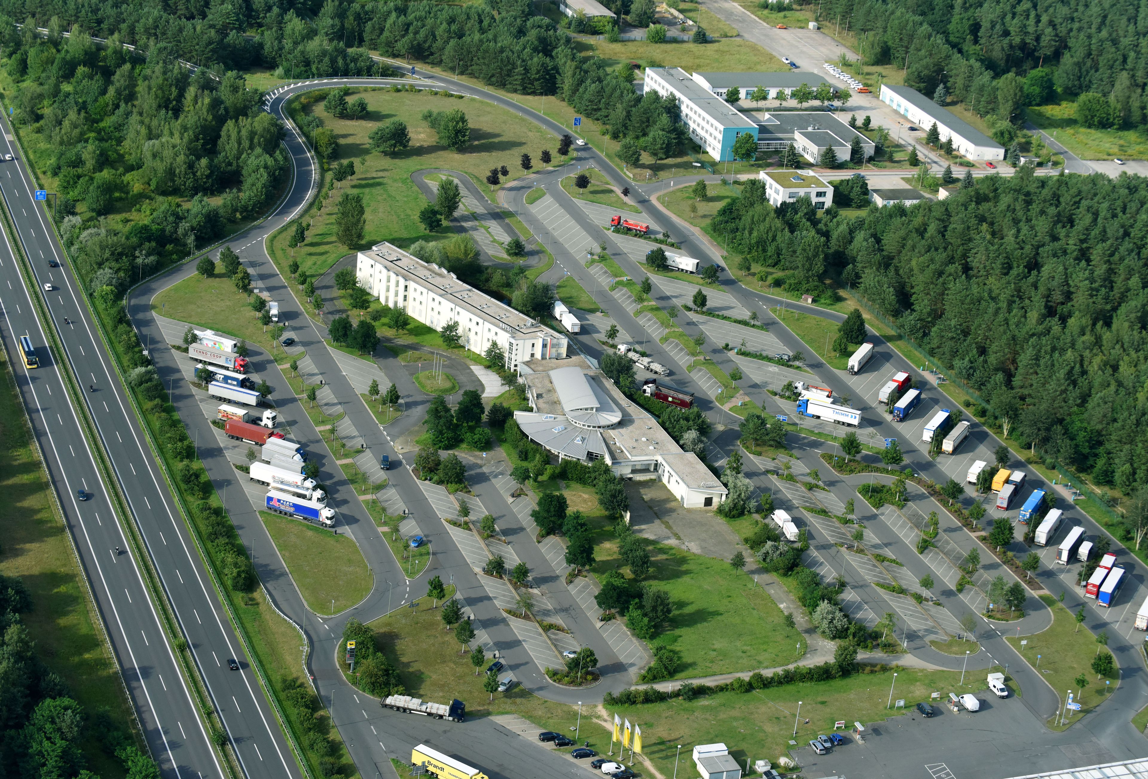 Vista aérea de uma área comercial com várias estradas, estacionamentos e edifícios industriais.