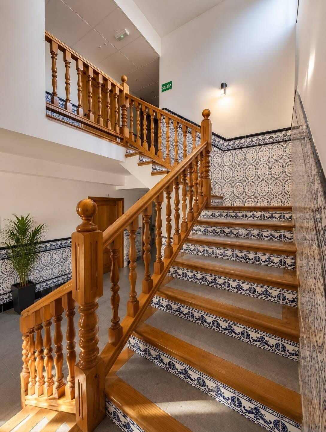Uma escadaria de madeira com um revestimento de azulejos estampados.