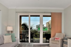 Uma sala de estar com sofá, poltrona e mesa com cadeiras.