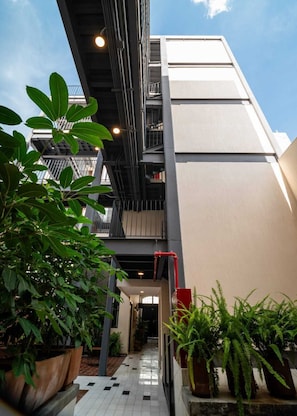 Um edifício moderno com escadas, plantas em vasos e piso de azulejos.