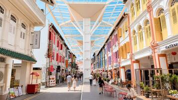 Uma rua pedonal coberta com lojas e restaurantes, apresentando um teto de vidro e arquitetura tradicional.