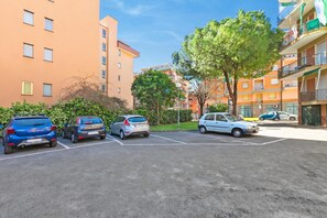 Um estacionamento com vários carros, rodeado por edifícios residenciais altos.