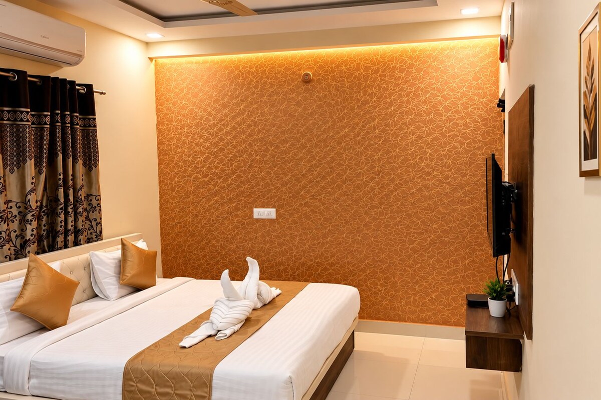 Quarto de hotel com cama, TV de tela plana, ar condicionado fixado na parede e papel de parede estampado.