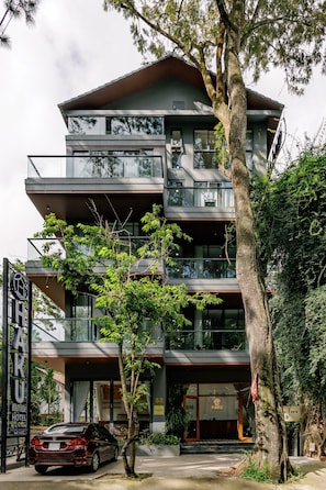 Hotel de vários andares com design moderno, com varandas e janelas amplas.