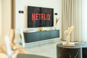 Apartamento luxo, sacada, vista para a piscina | Área de estar | TV de tela plana 57 polegadas com canais via satélite