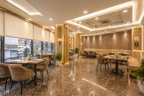 Um restaurante moderno com piso de mármore, tetos altos e vista para a cidade.