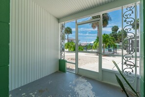 Quarto com vista para palmeiras e um edifício ao longe.