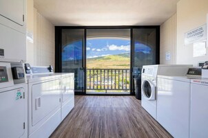 Uma lavanderia com vista para a paisagem através de uma porta de vidro.
