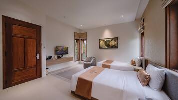 Quarto de hotel com duas camas, um sofá, uma televisão e um quadro na parede.