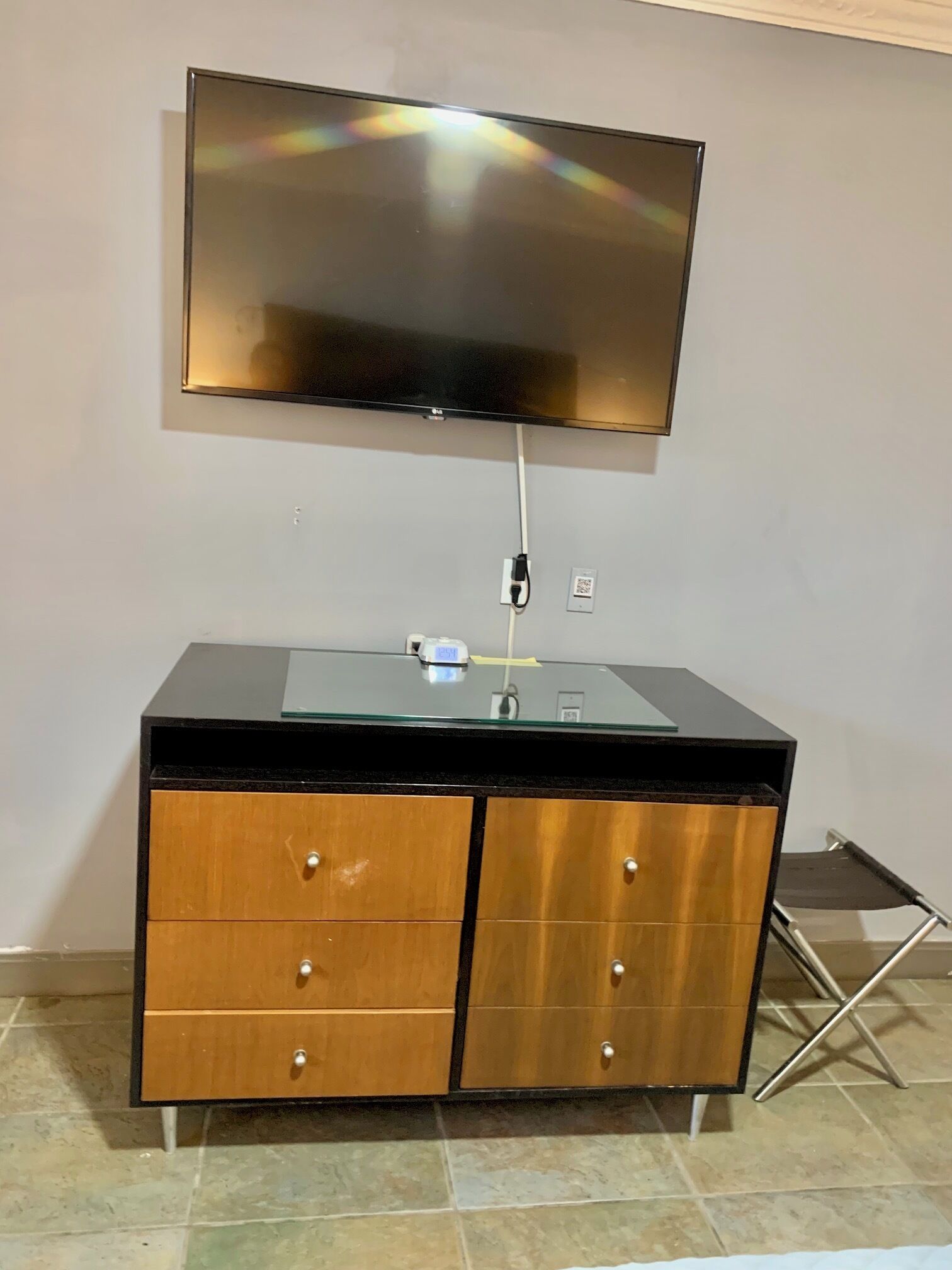 Casa de banho moderna com toucador preto, espelho e televisão montada.