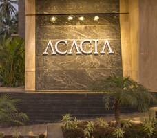 Fachada de prédio com o nome 'ACACIA' exibido em grandes letras.
