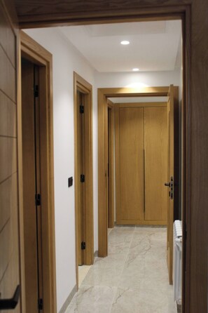 Um corredor com portas de madeira e um radiador.