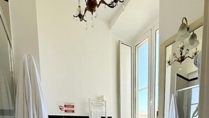 Casa de banho com sanita, bidé e lavatório, azulejos no chão com padrão hexagonal e área de duche.