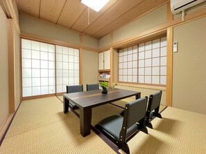 Um quarto japonês tradicional com tatames, uma mesa baixa e biombos shoji.