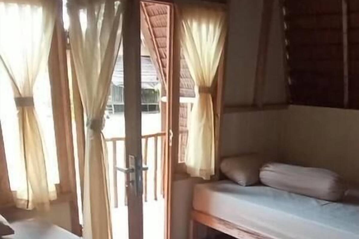 Um quarto com uma cama, um banco e uma mesa com um tapete.