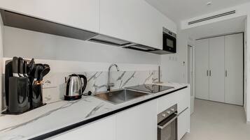 Uma cozinha moderna com bancada de mármore, eletrodomésticos de aço inoxidável e forno embutido.