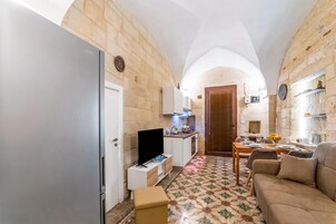 Um espaço compacto com cozinha compacta, área de refeições e sofá.