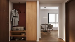 Quarto moderno com guarda-roupa, cabide, mala, área de refeições com cadeiras e uma mesa.