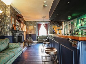 Uma área de bar com banquetas, balcão e lareira.